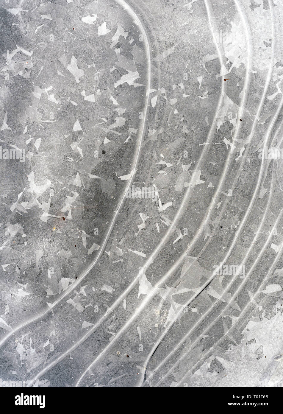 Cracked splt ice in winter caused from frozen water in puddles and wind ...