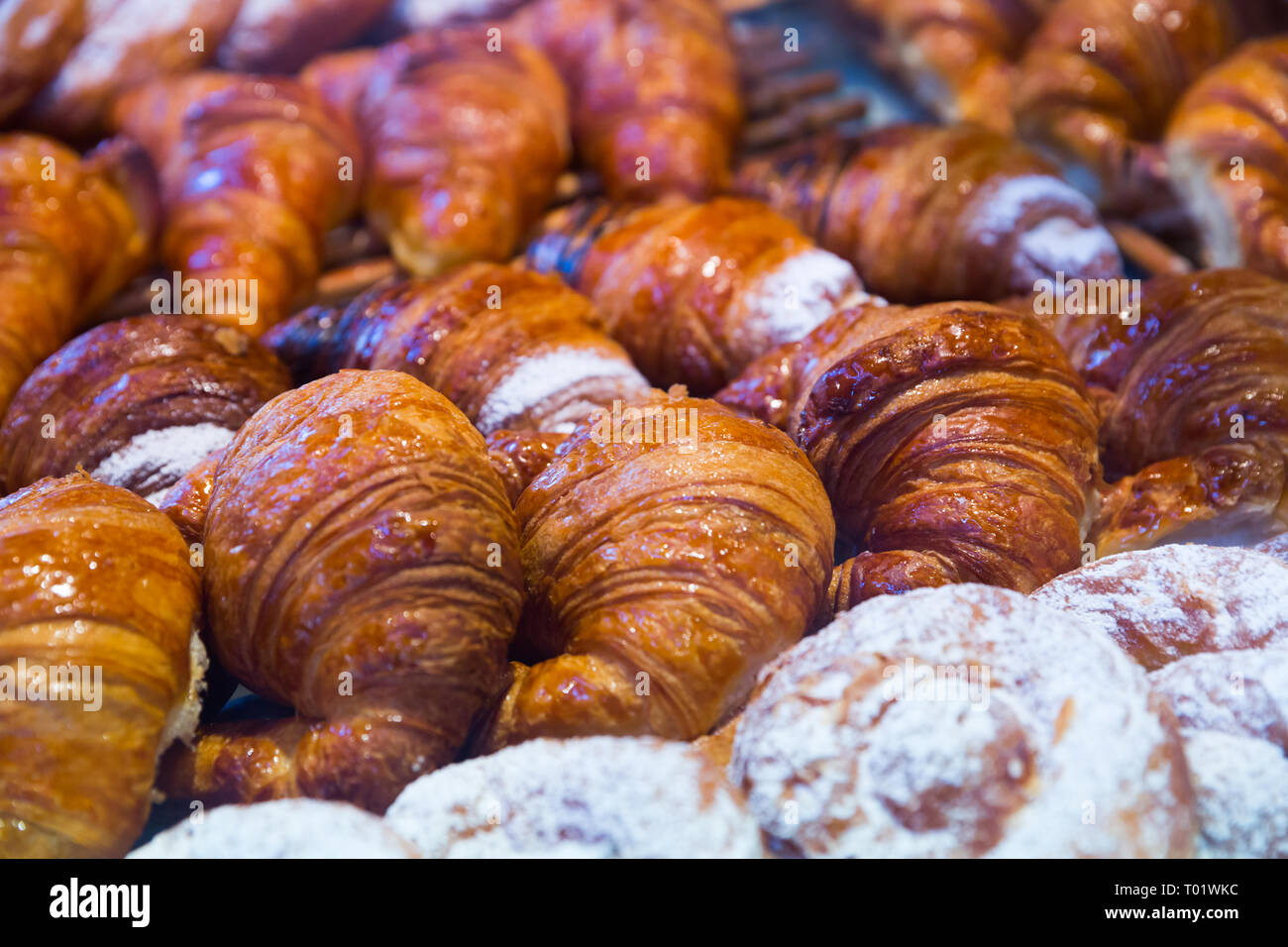 View of glass display with various croissants in pastry shop in Europe ...