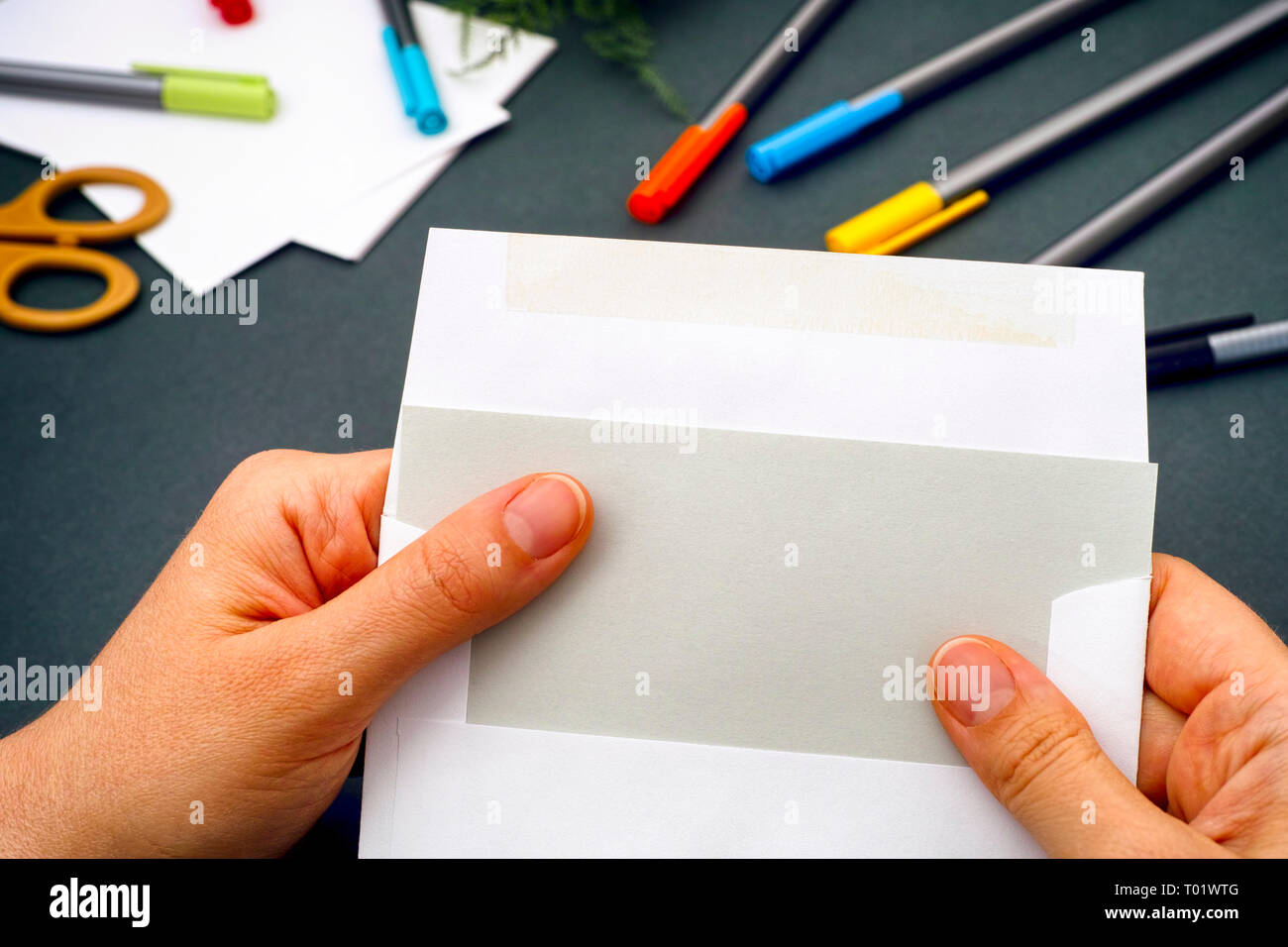 Woman hand taking out letter from envelope. Office supplies on ...