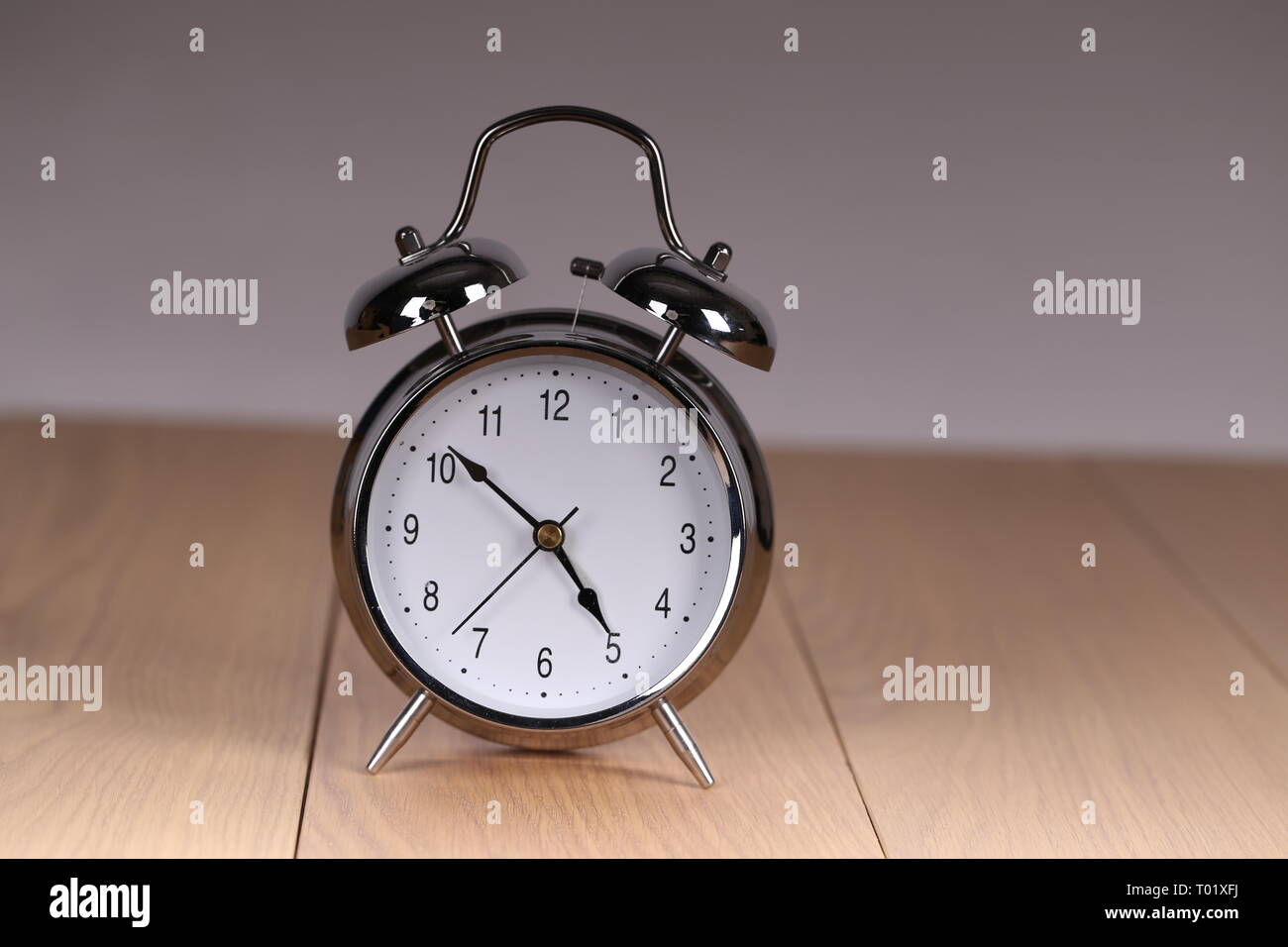 The old alarm clock on a light background Stock Photo - Alamy