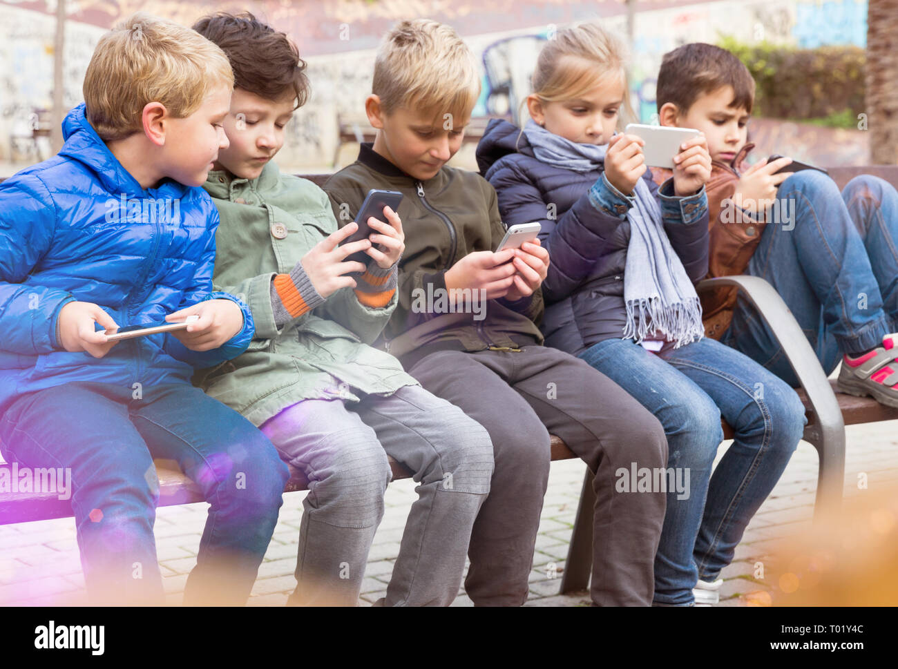Children playing on smartphone outdoors Stock Photo - Alamy