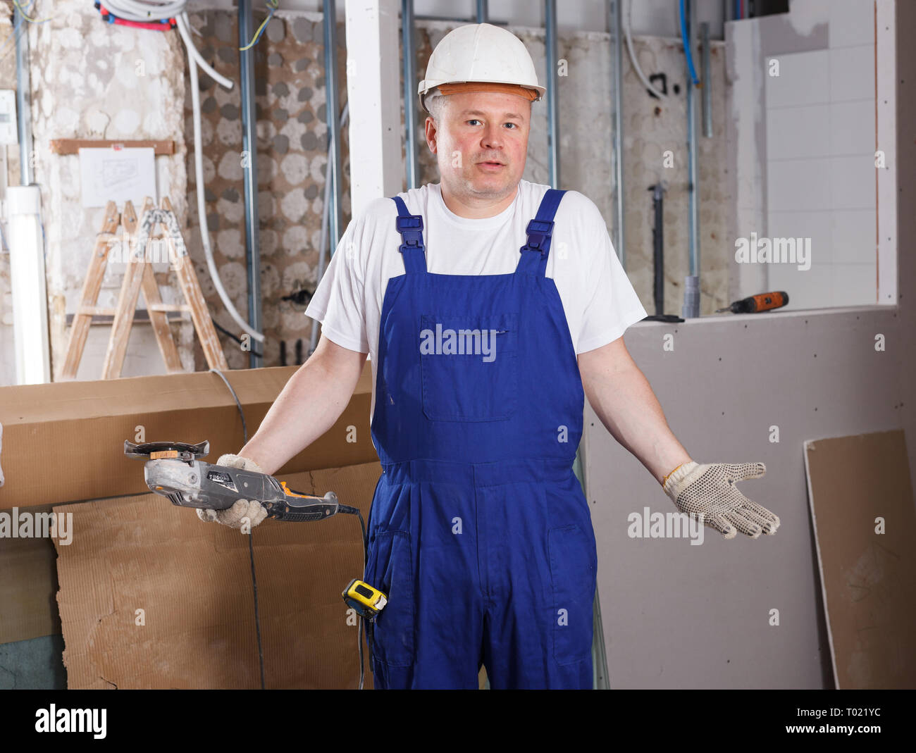 Scared and confused male contractor looking at room and determining ...