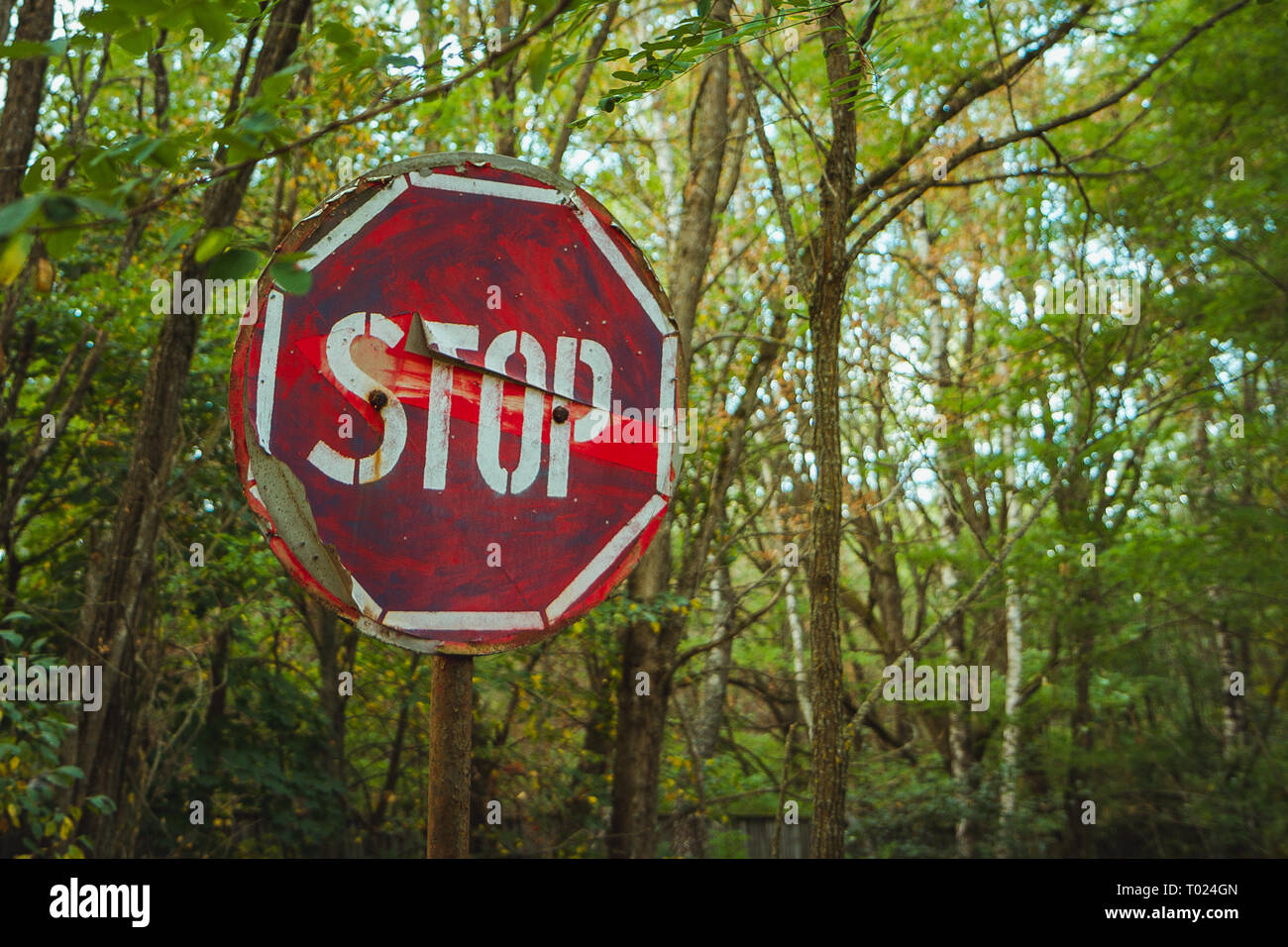 Stop sign - old rusty, frayed, scratched red road sign in radioactive ...