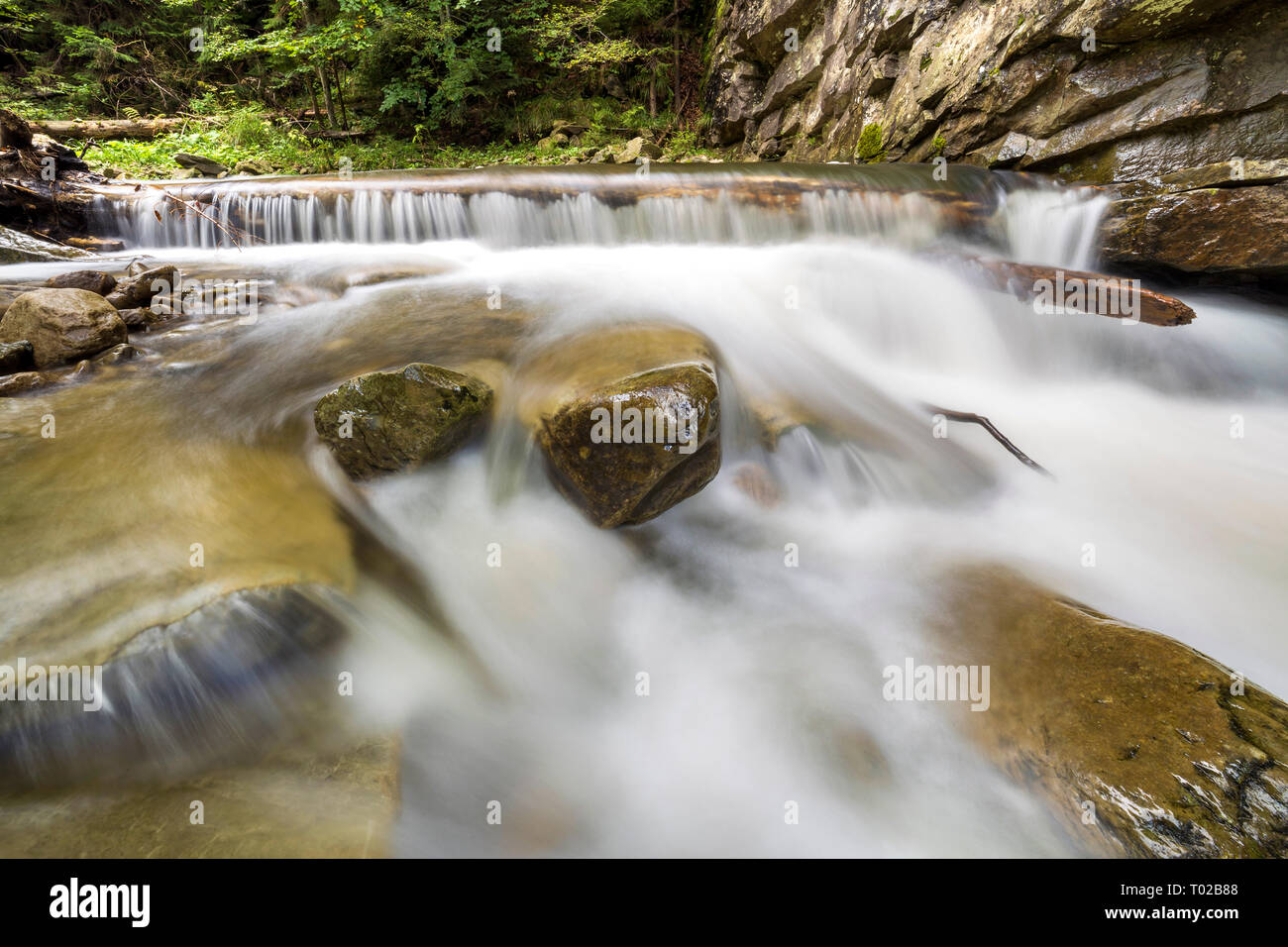 Fast flowing river stream with smooth silky water falling from big ...