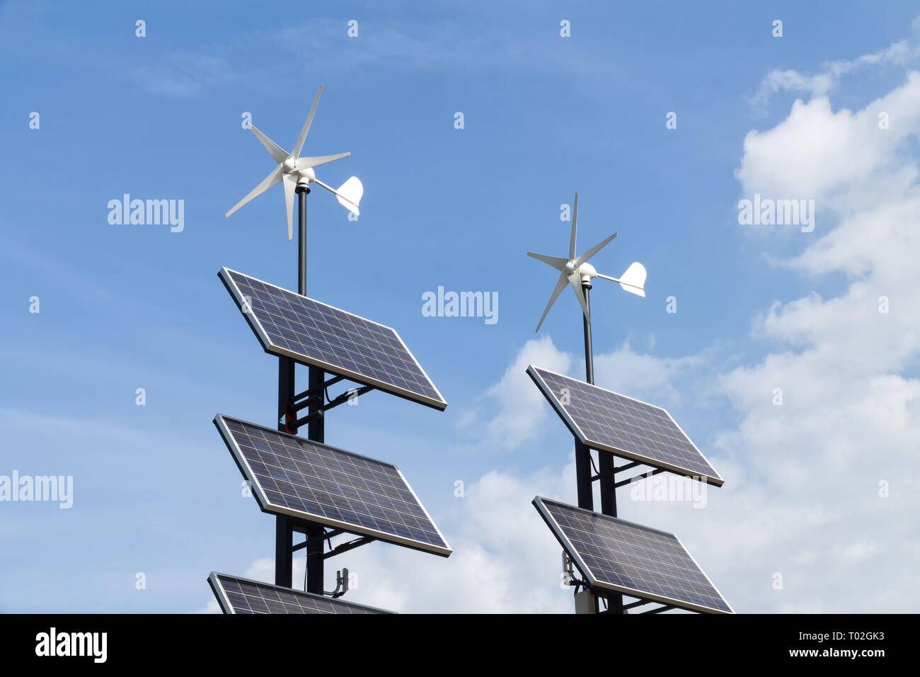 Small wind power generators and set of Solar panels agains blue sky ...