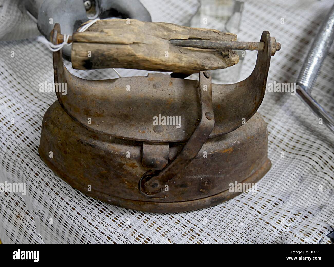 Vintage original iron with a broken handle covered by chipped wood ...