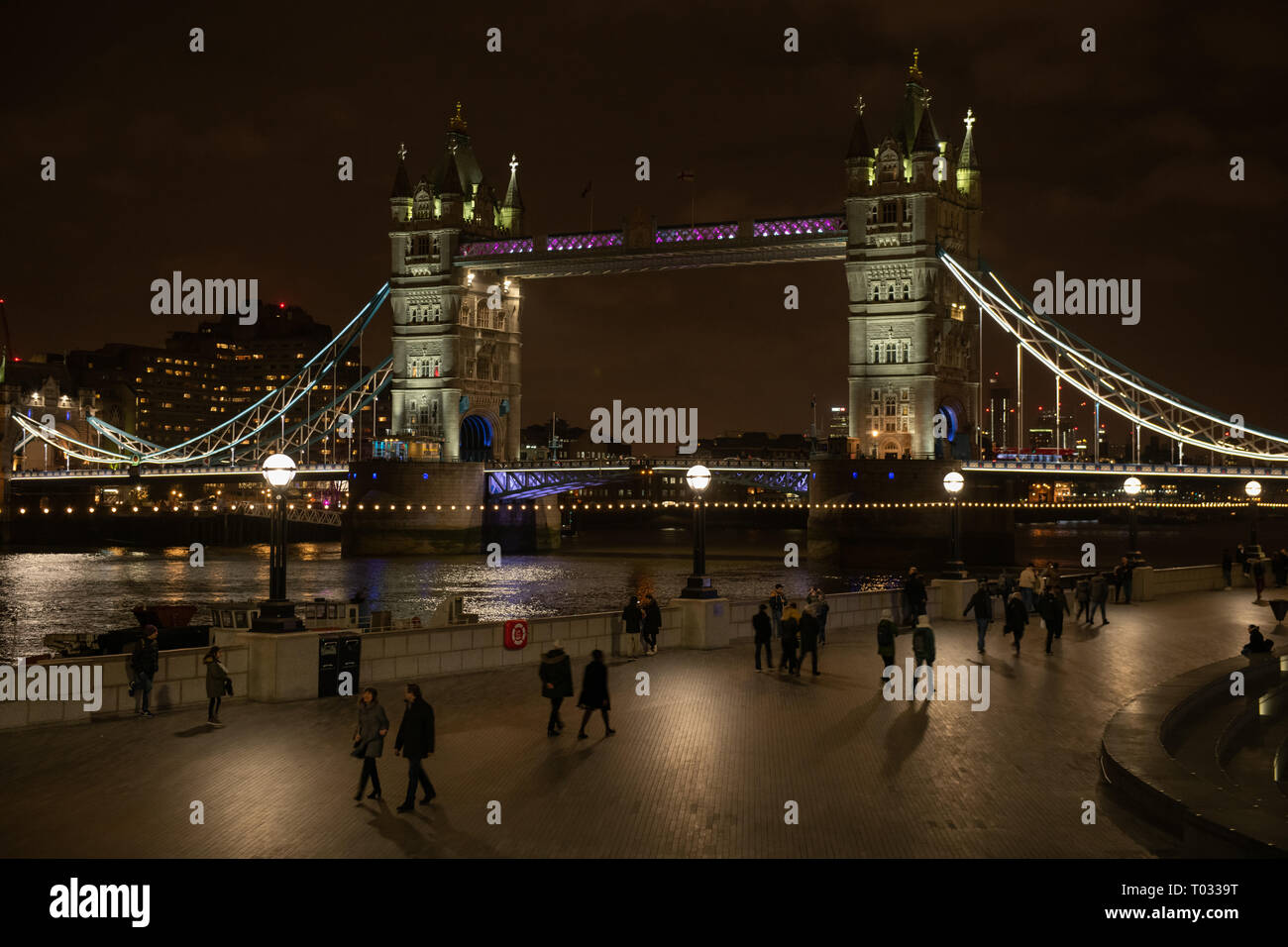 Tower Bridge, London, Illuminated at night with people in foreground ...