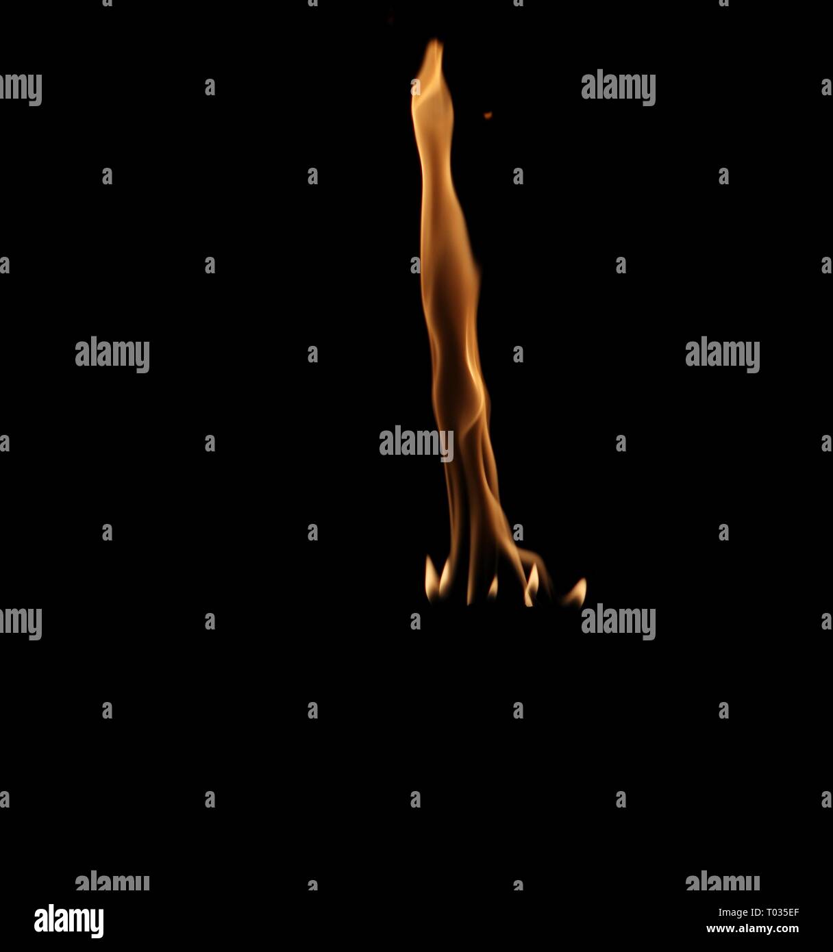 Flames from a burning torch rising straight up with smaller flames at ...