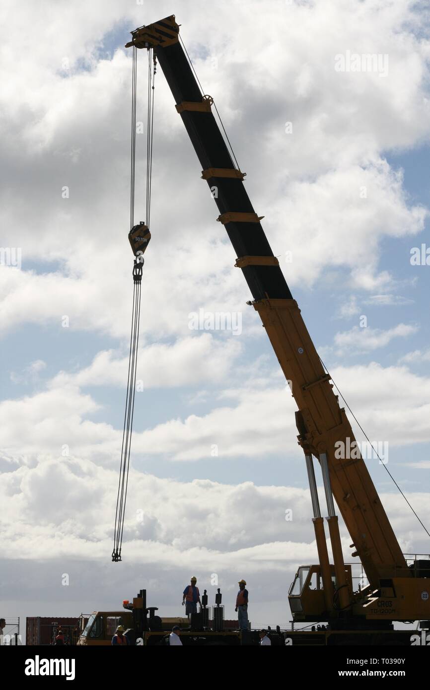 SAIPAN, CNMI—MARCH 2016: Power crane and silhouettes of workers at a ...