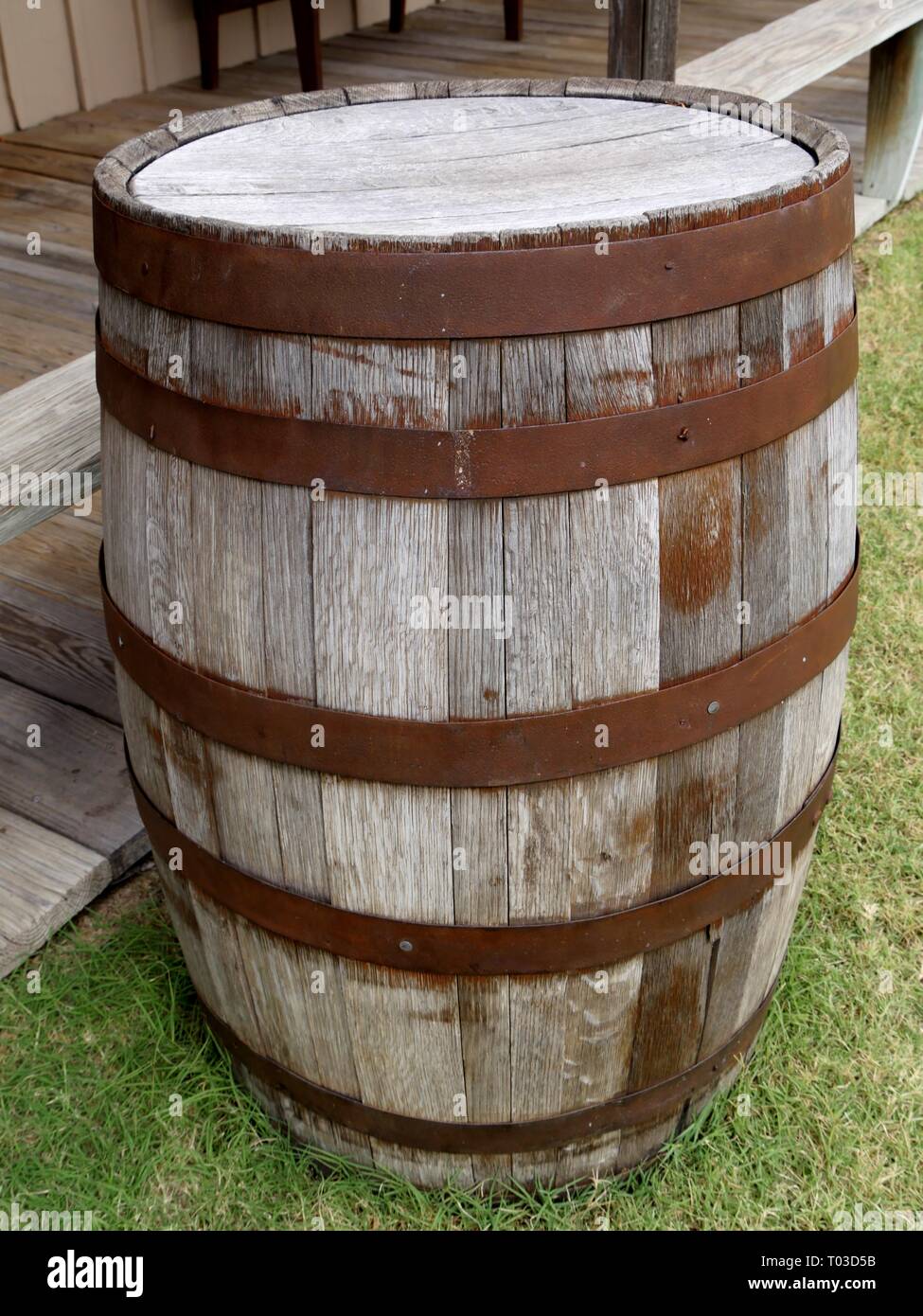Rustic wooden barrel on a grassy ground, leaning against wooden floors ...
