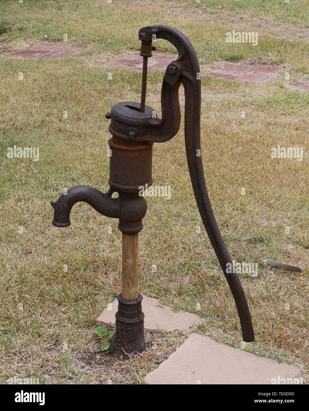 Antique rusty water pump in a grassy yard Stock Photo - Alamy