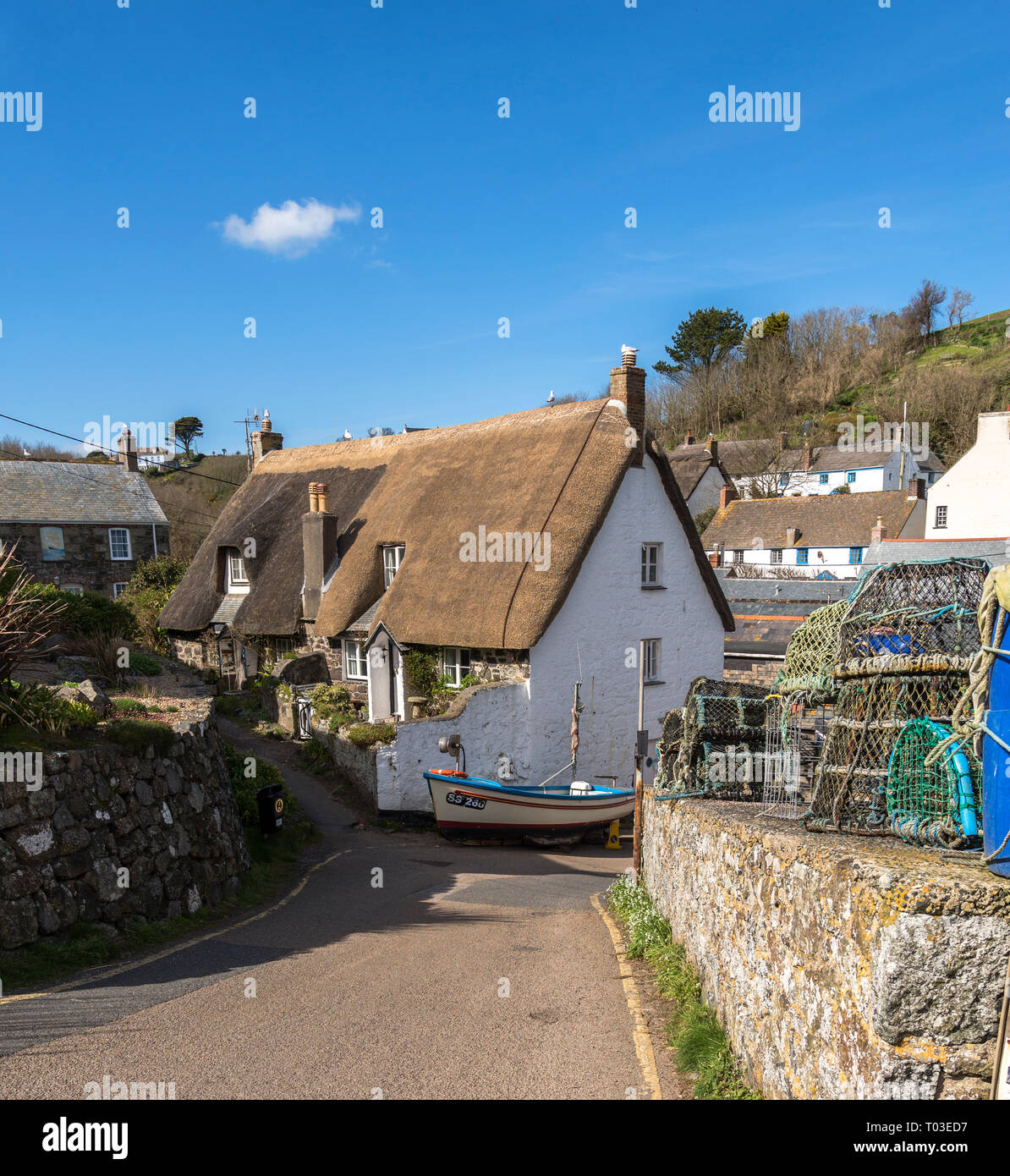 Fishing boat and thatched cottage and crabpots under a blue sky in the ...