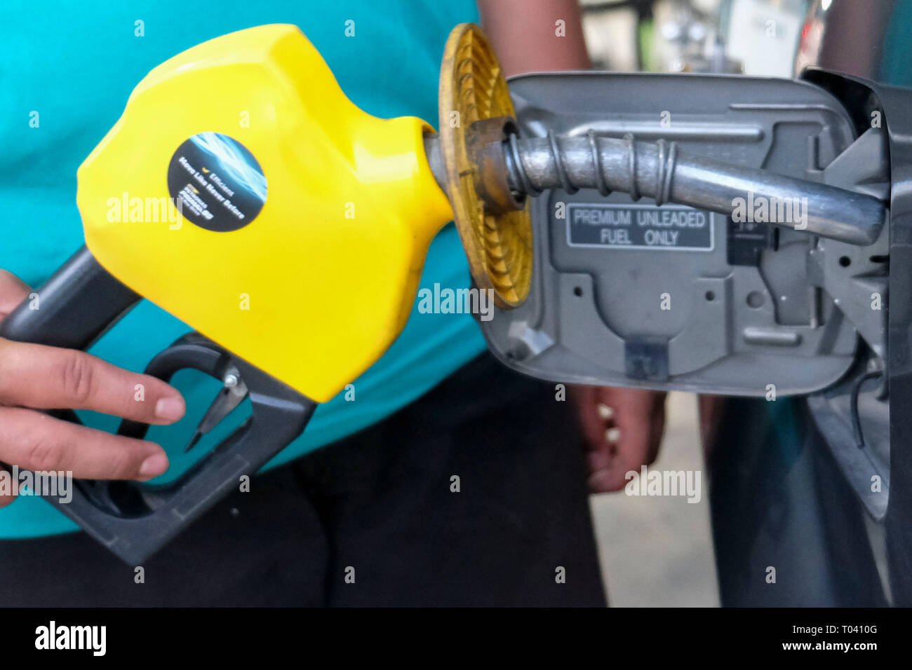 A man seen holding the petrol nozzle at a Petronas oil and gas station ...