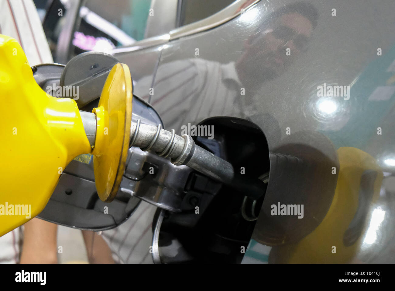 A man seen holding the petrol nozzle at a Petronas oil and gas station ...