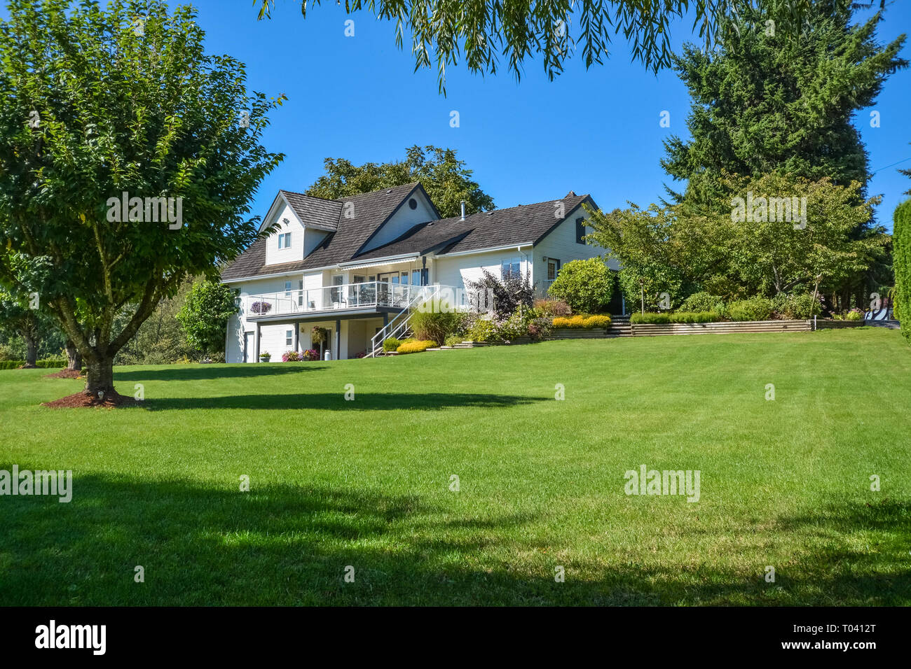 Big family house on a farm. Residential house with big green lawn in ...