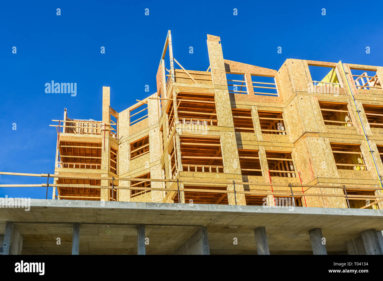 New low-rise building up on concrete base of first level on sunny day ...