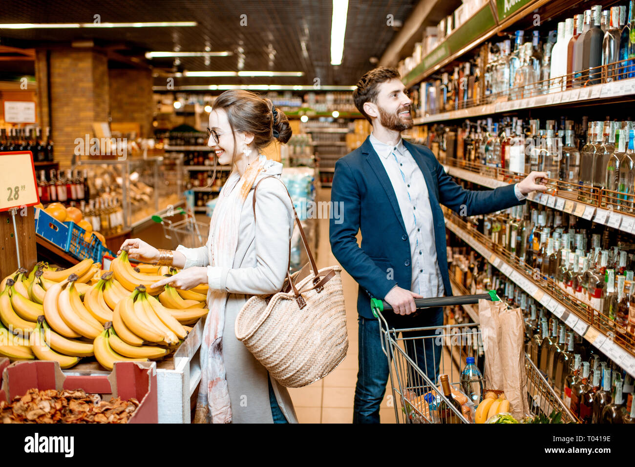 Young couple buying alcohol and fruits in the supermarket Stock Photo ...