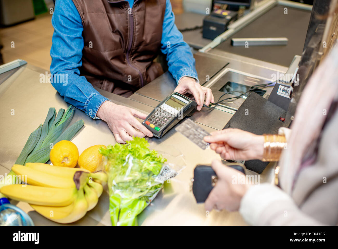 Paying with credit card at the cash register, buying food in the ...