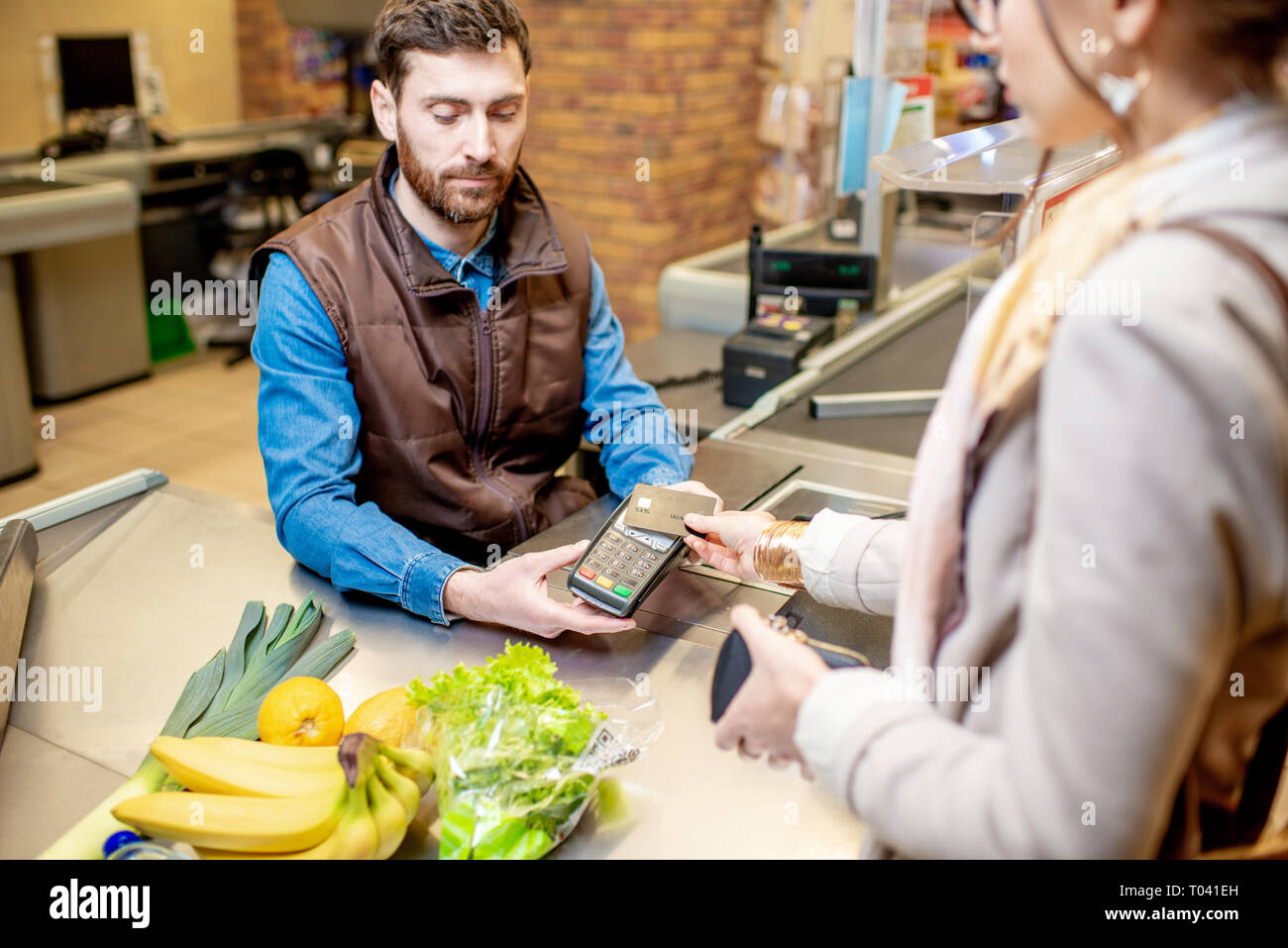 Young woman customer paying with a credit card for shopping at the cash ...