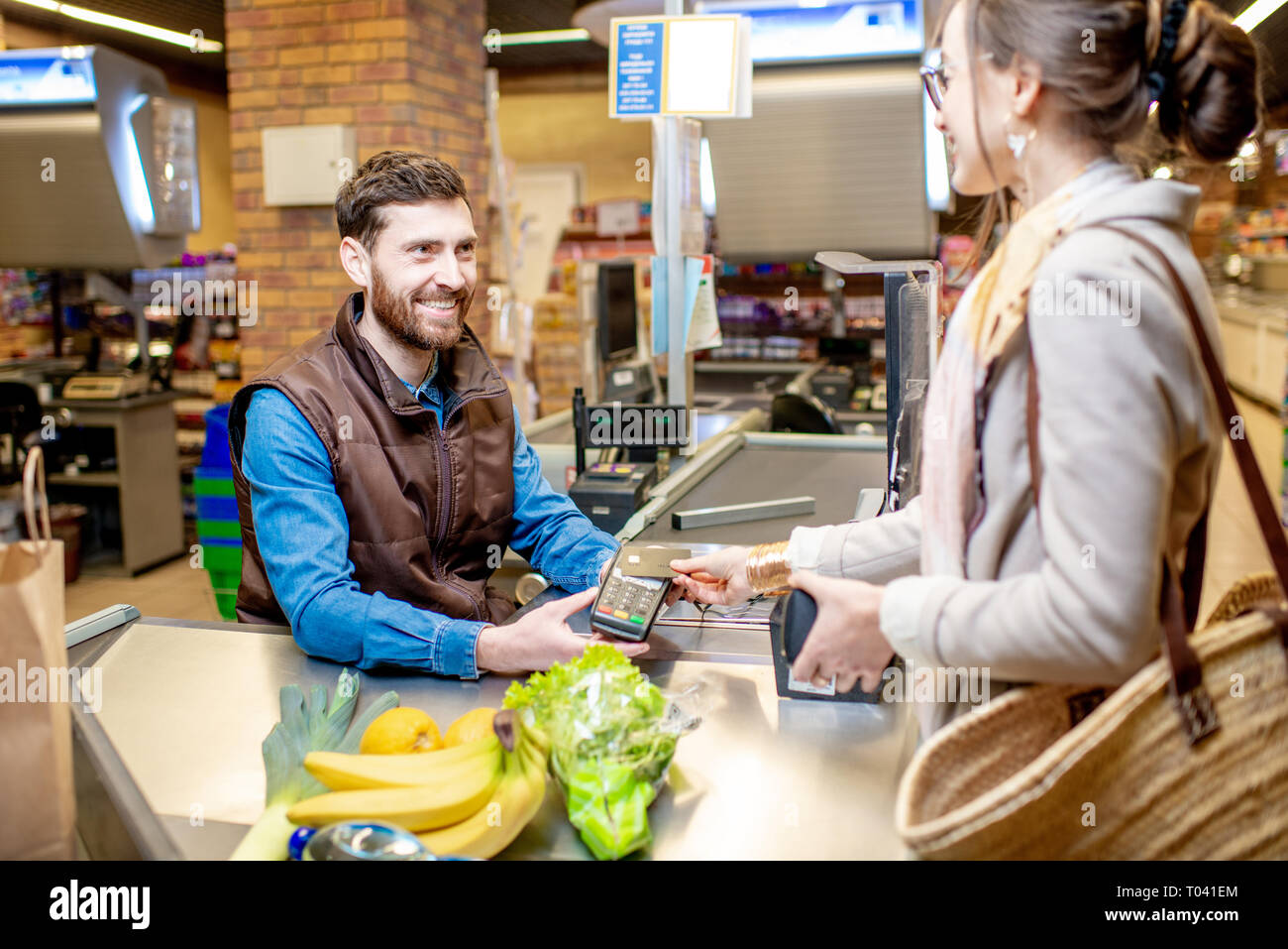 Young woman customer paying with a credit card for shopping at the cash ...
