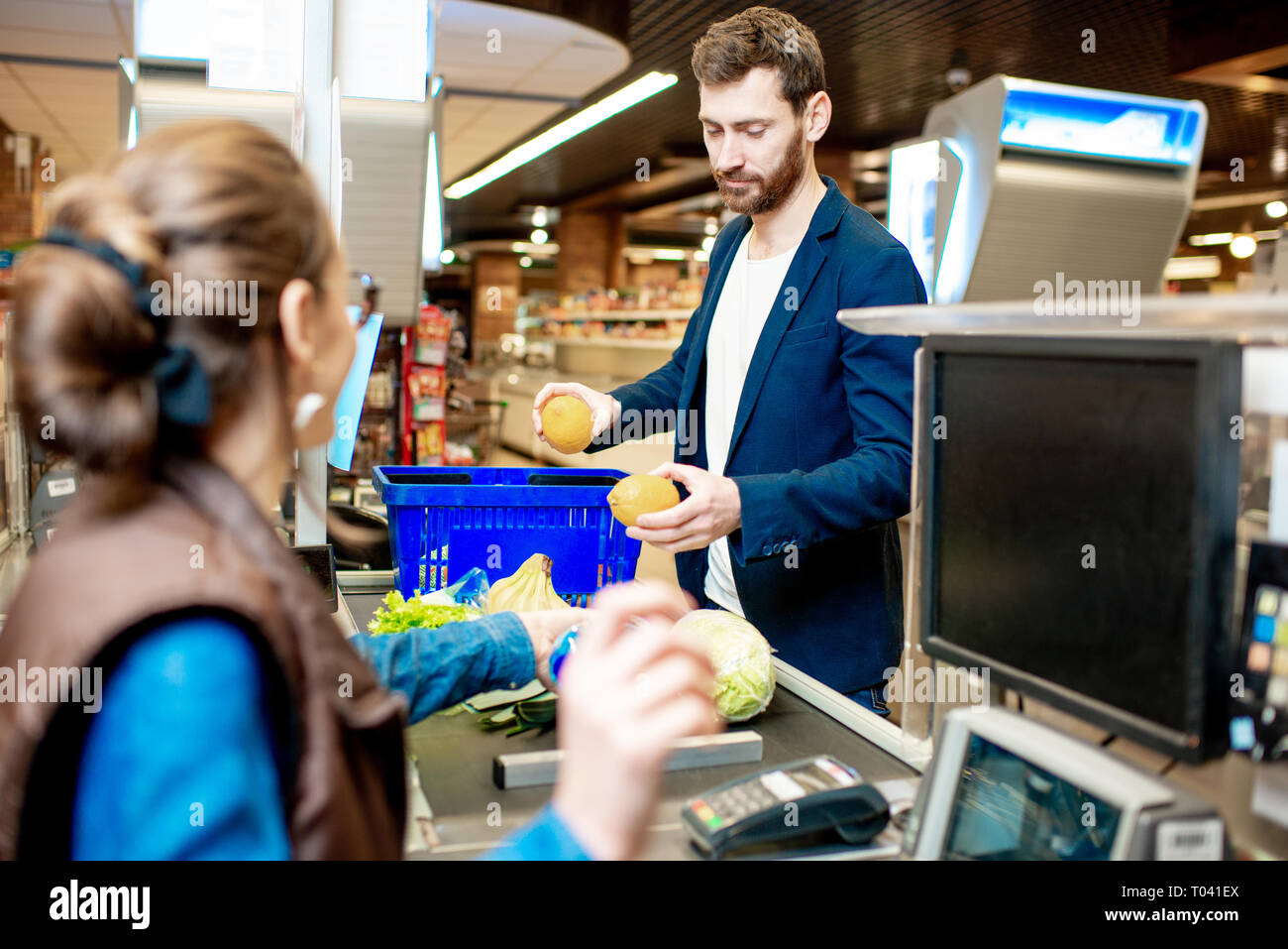 Handsome businessman putting products on the cash register buying food ...
