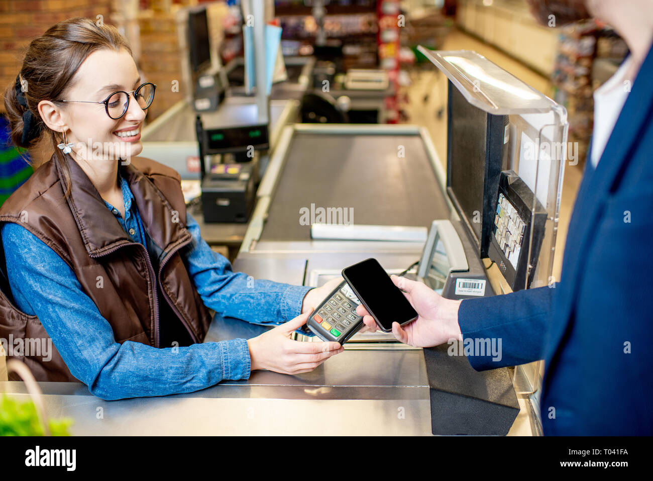 Man paying with a credit card for shopping at the cash register with ...
