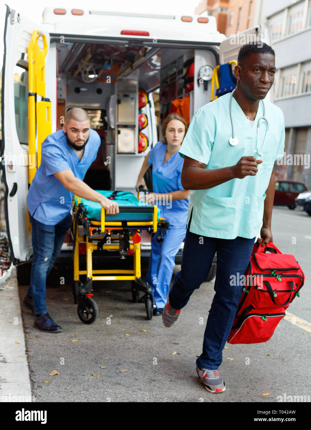 Three positive pleasant friendly efficient ambulance doctors posing in ...