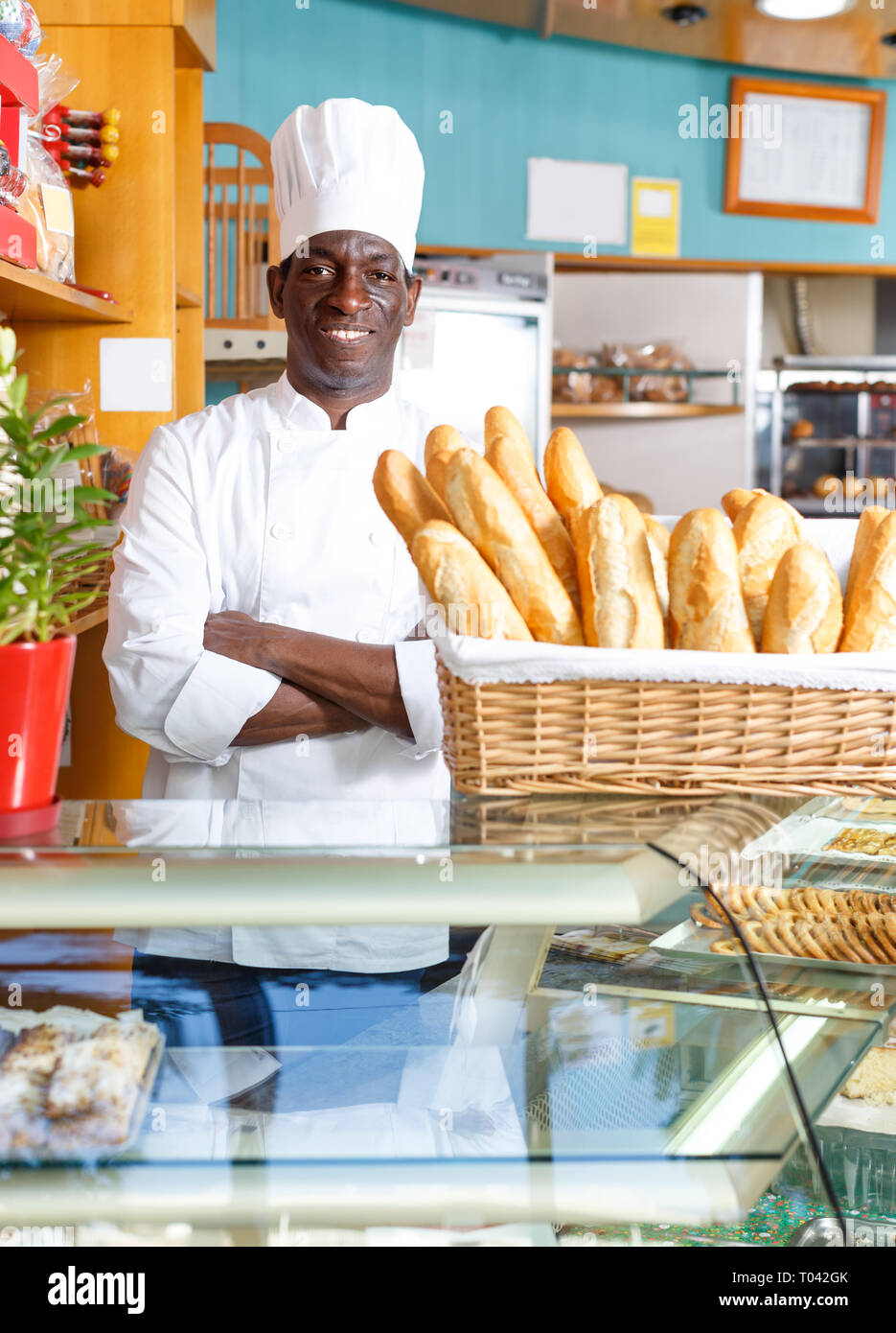Proud owner of bakery shop wearing white uniform standing with arms ...