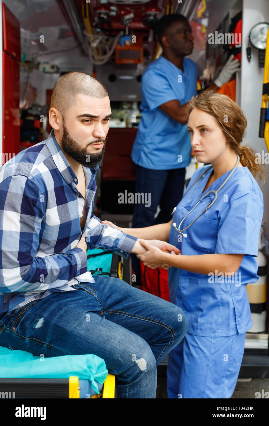 Diligent serious positive emergency doctors providing first aid to man ...