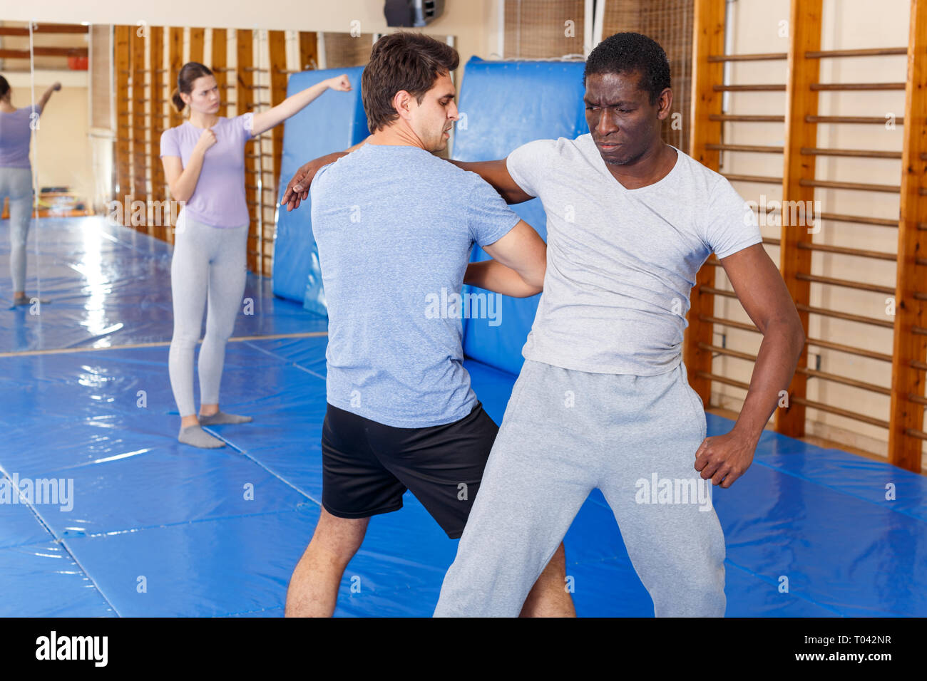 Two young men practicing self defense techniques in sports club Stock ...