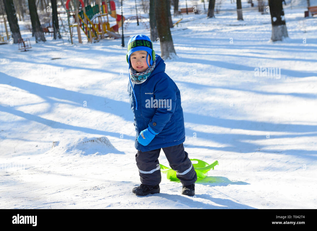 Boy riding toboggan in Mariininskiy park. December 21, 2018. Kiev ...