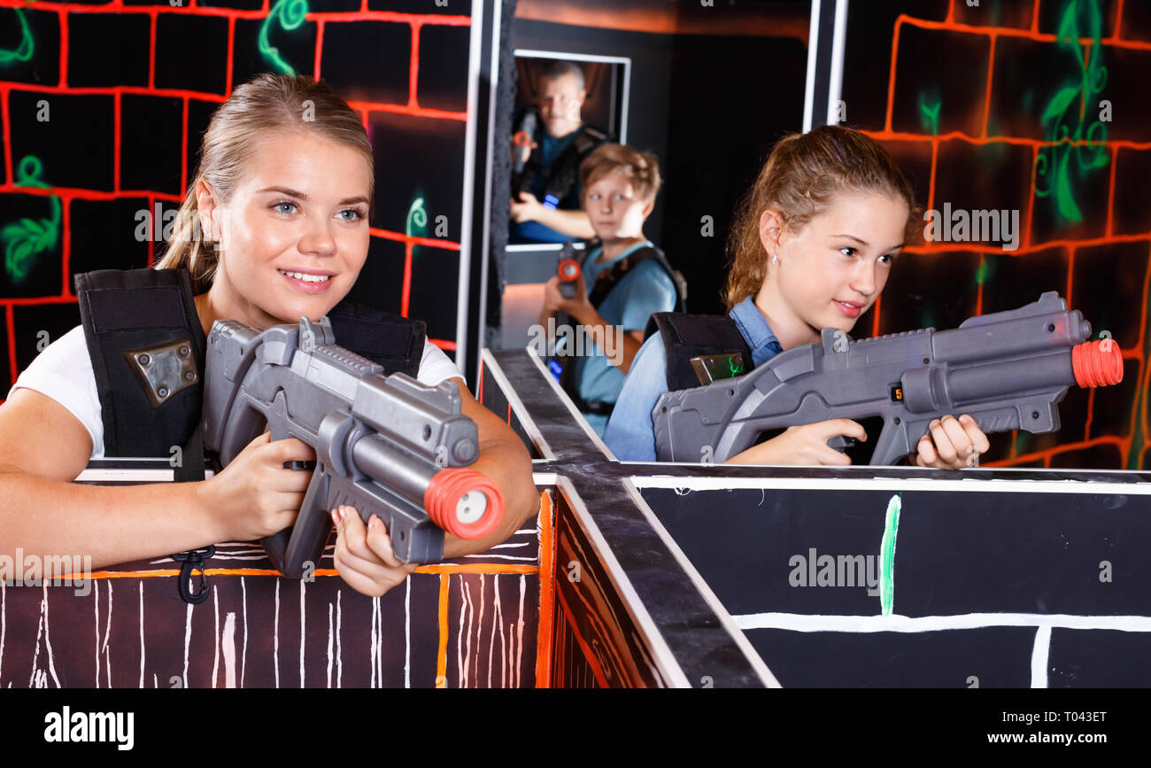Modern young cheerful positive woman and teen girl with laser pistols ...