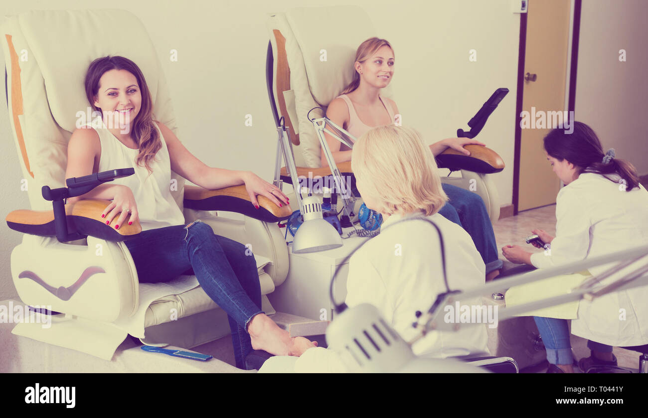 Two girl clients having pedicure done in nail salon Stock Photo - Alamy