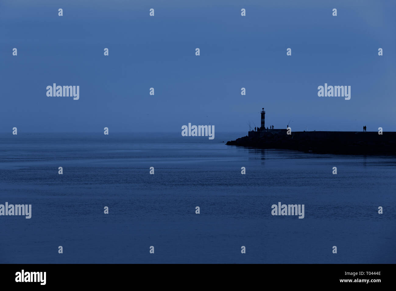 Calm sea dusk at the pier of the Ave river mouth harbor, Vila do Conde ...