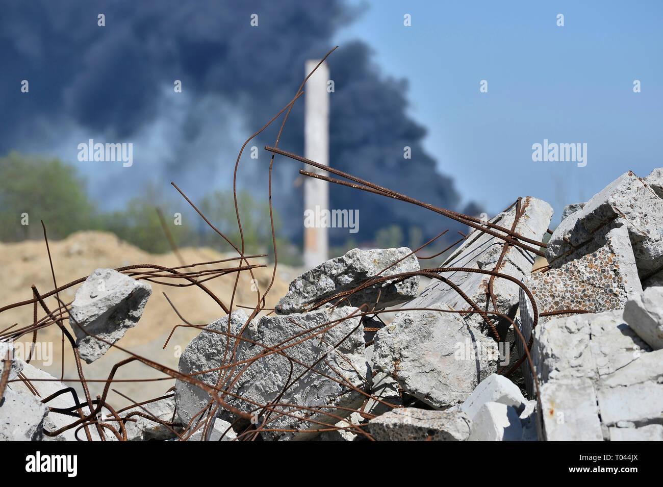 A pile of concrete rubble with protruding rebar on the background of ...