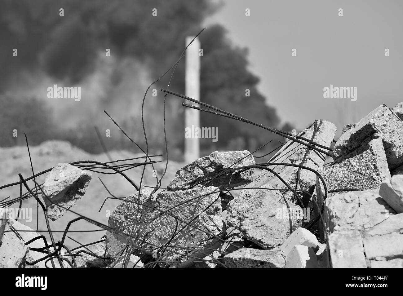 A pile of concrete rubble with protruding rebar on the background of ...