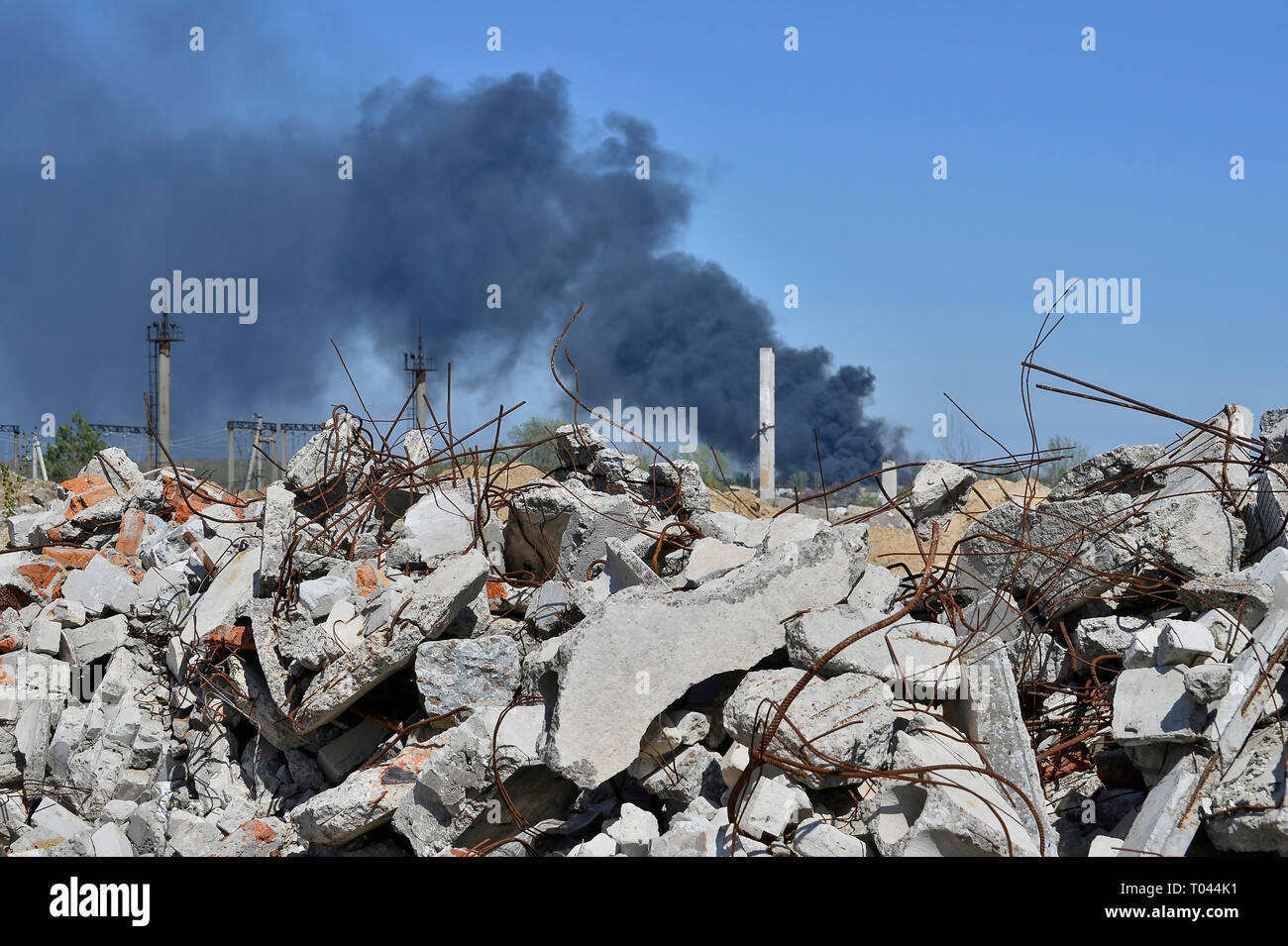 A pile of concrete rubble with protruding rebar on the background of ...