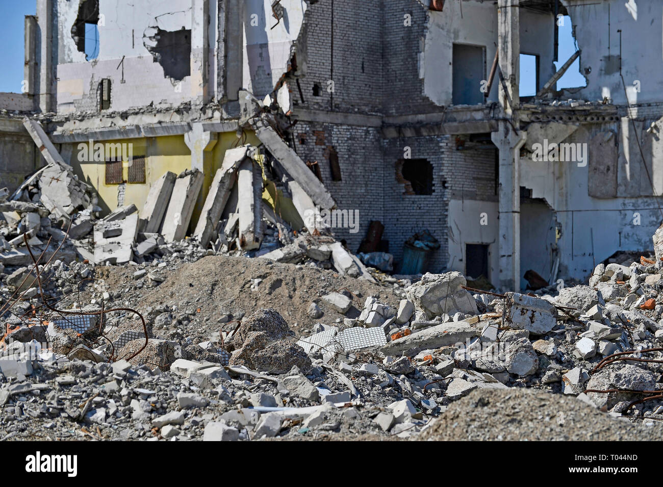 A pile of concrete debris on the background of a large destroyed ...