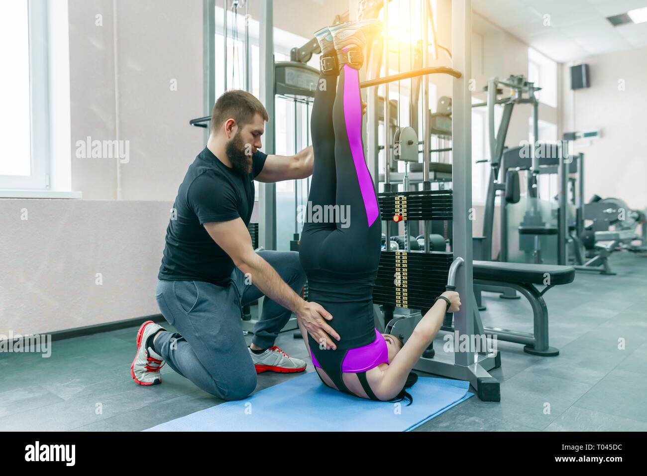 Young woman doing rehabilitation exercises with personal instructor ...