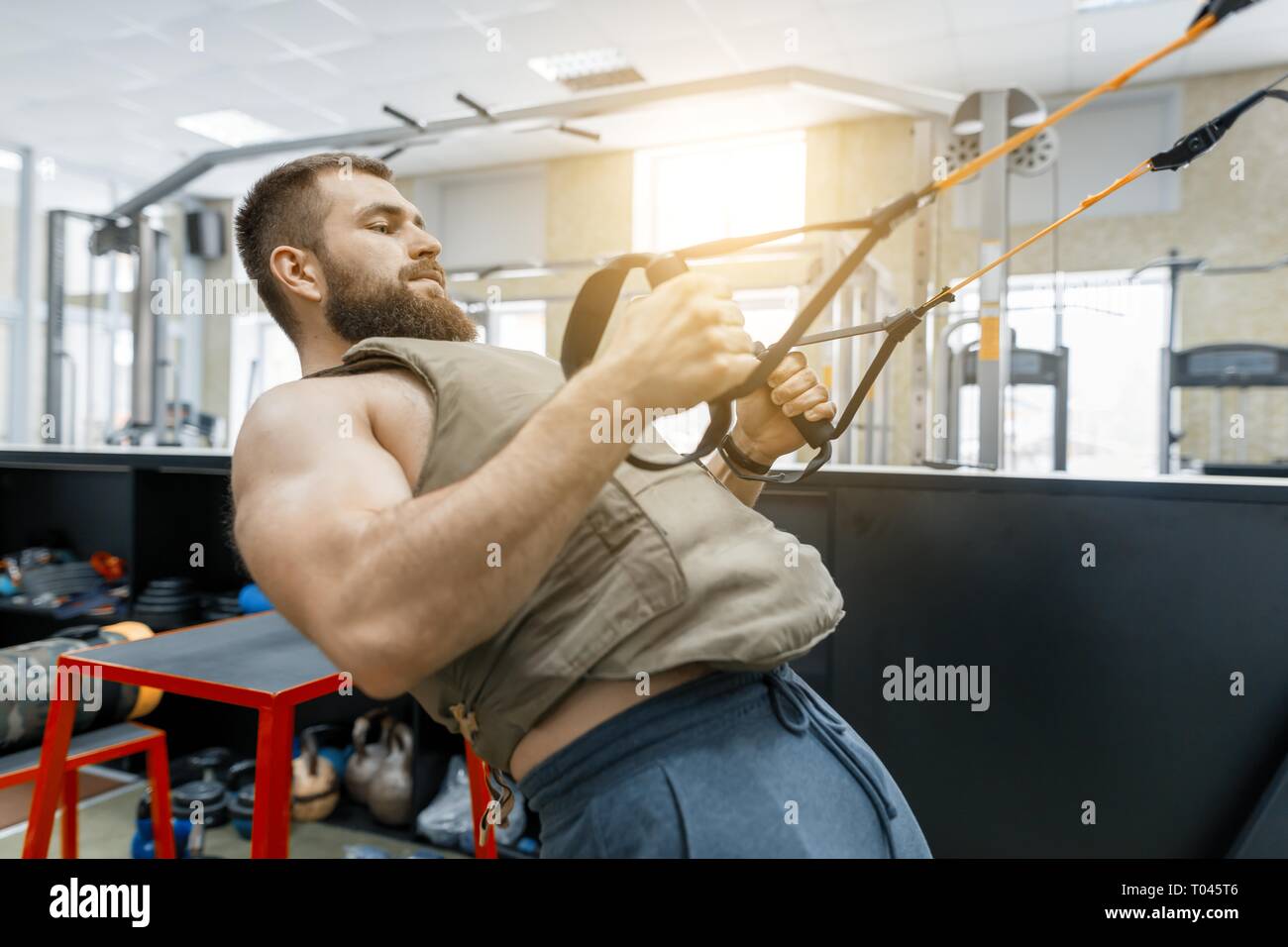 Muscular bearded man dressed in military weighted armored vest doing ...