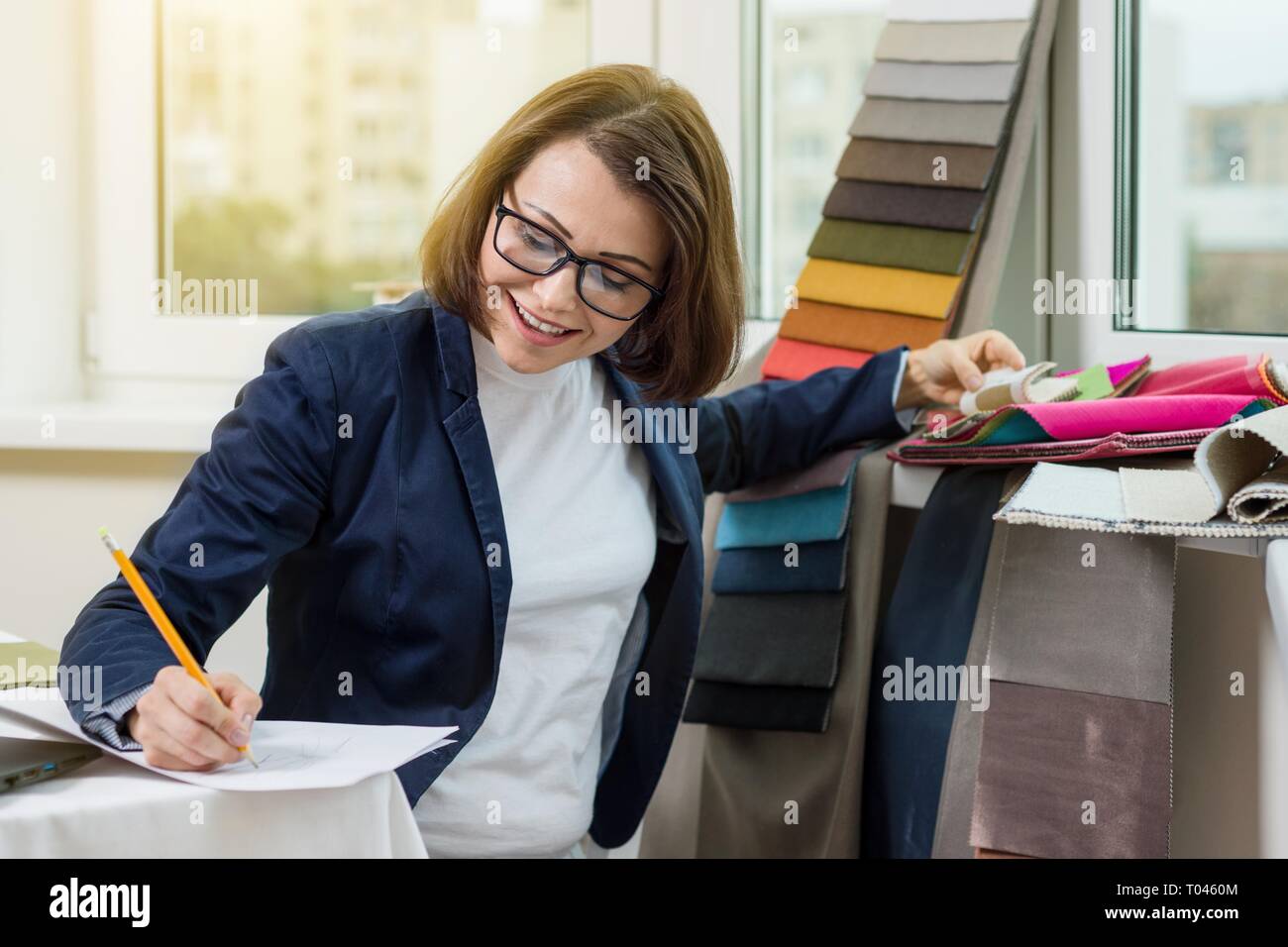Interior designer, at the workplace in the office with samples of ...