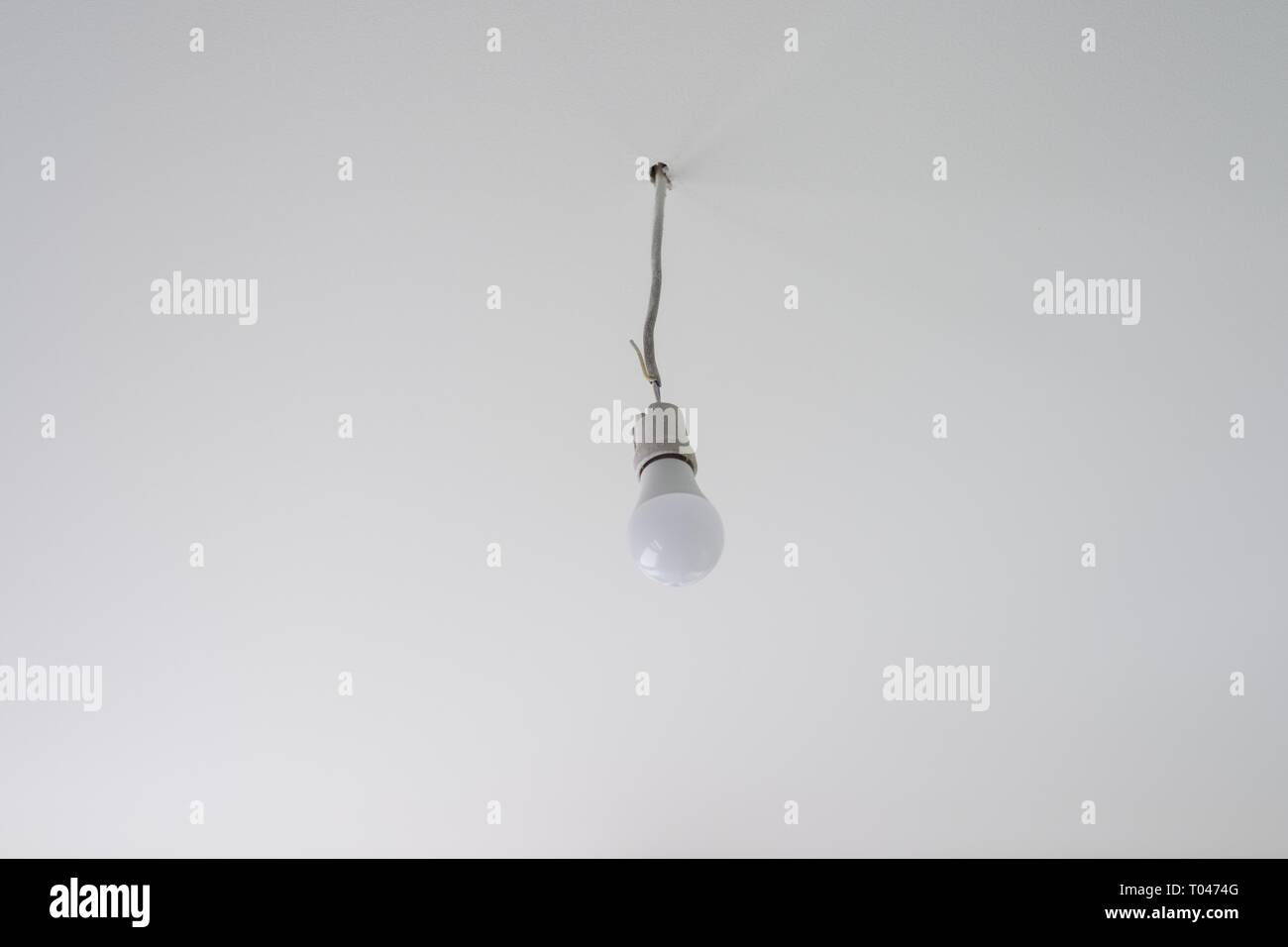 LED light bulb on white ceiling. Temporary lighting during repair Stock ...