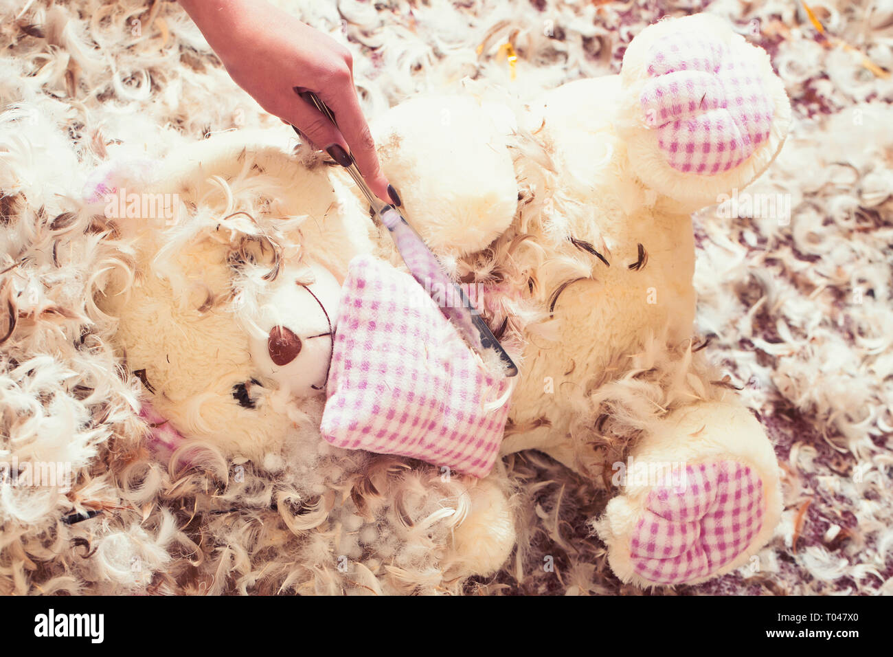 Hand rip teddy bear with knife. Cute animal doll in feather snowflakes ...