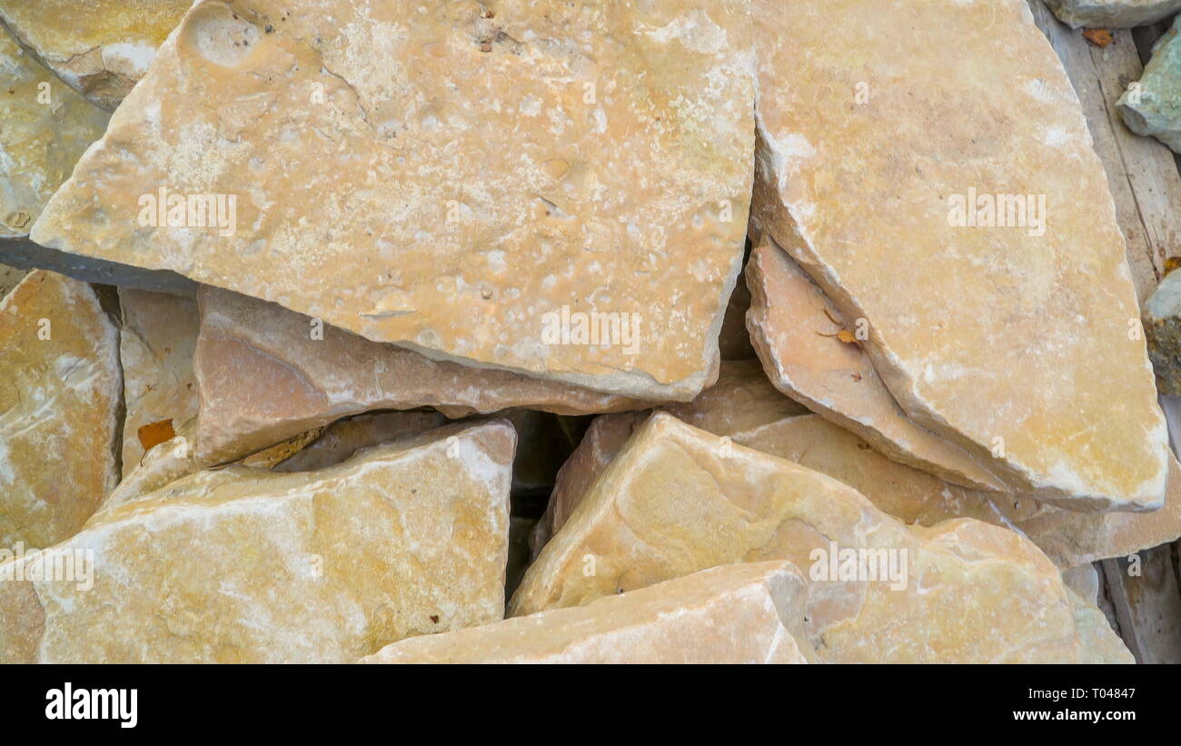 The white and yellow colored limestone rocks on the floor of a showroom ...