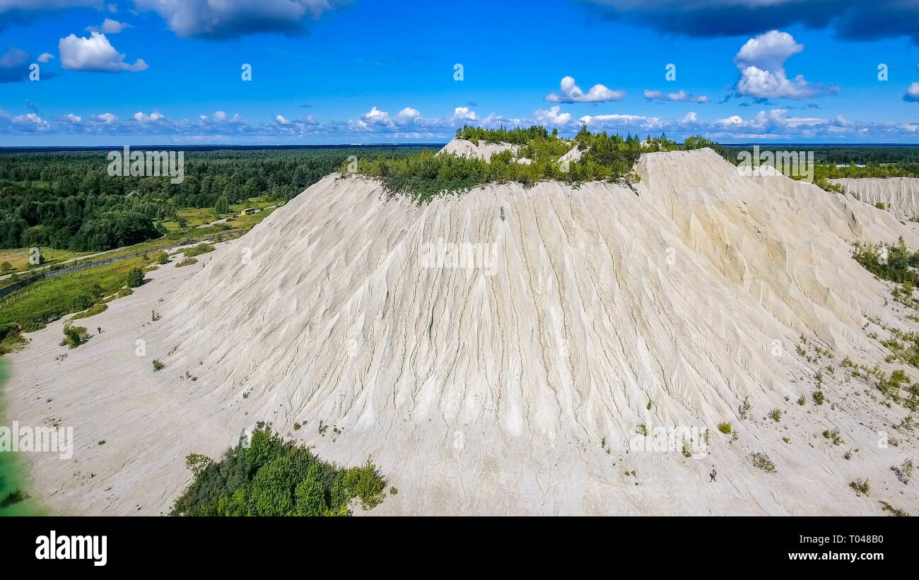 Closer aerial view of the white limestone quarry with the lake ...