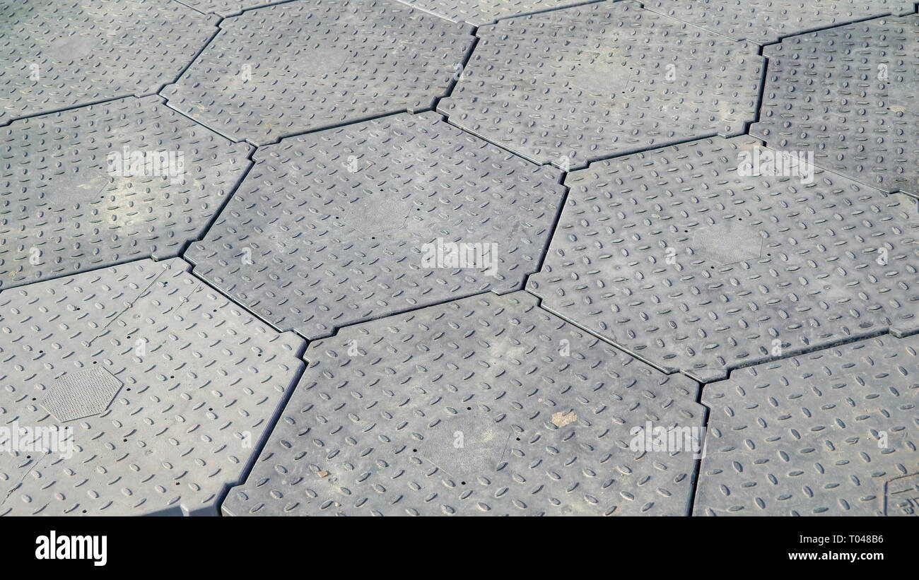 The hexagonal shape of the metal flooor with small spots on the metal ...