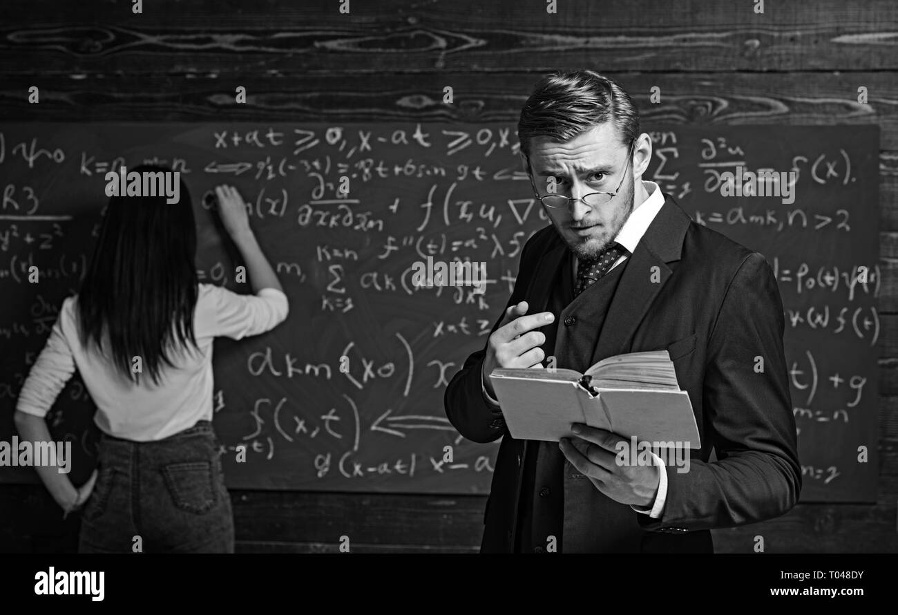 Strict teacher in glasses giving explanations while holding book. Tutor ...