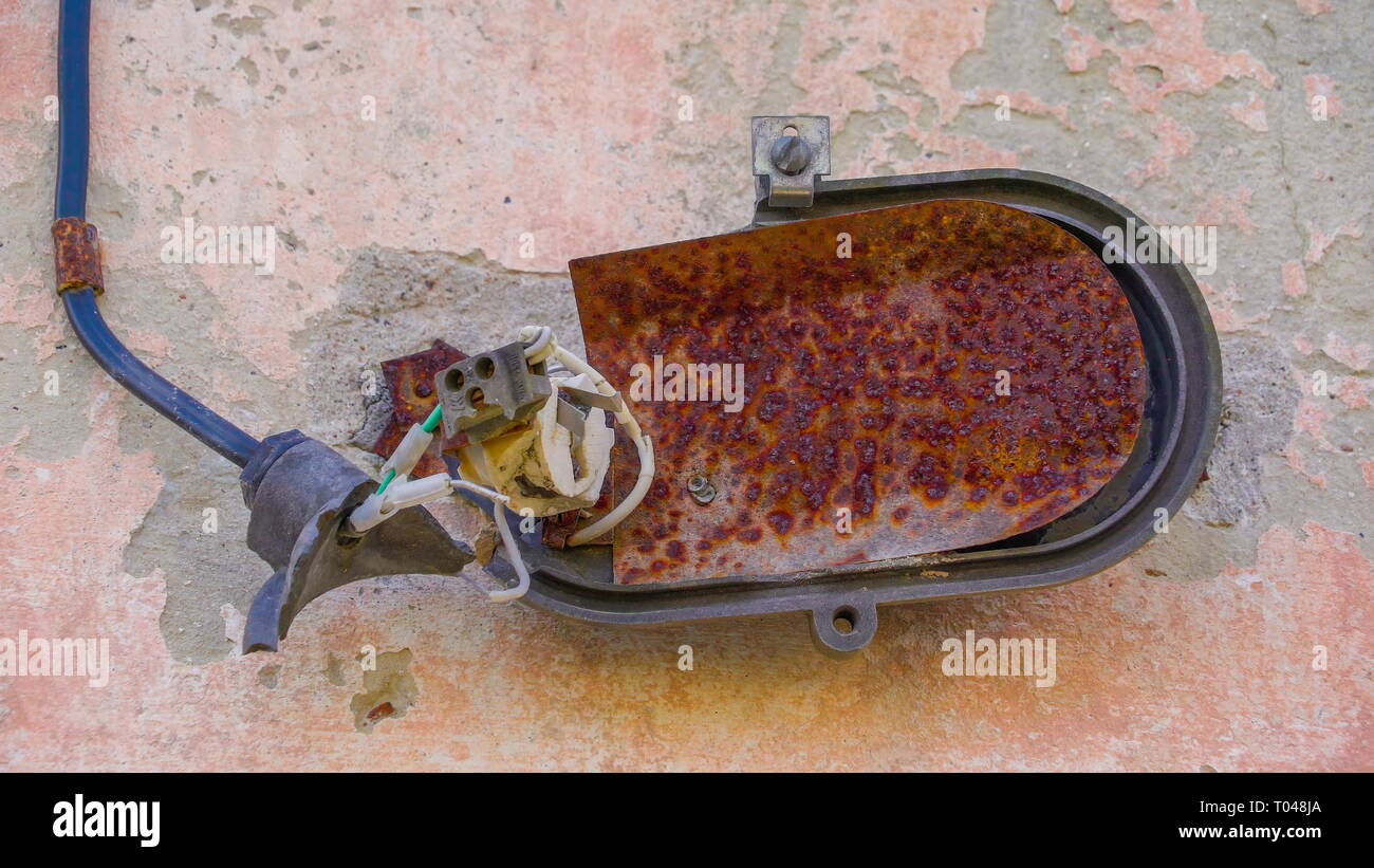 Close up look of the broken lamp on the wall of a house damaged from ...