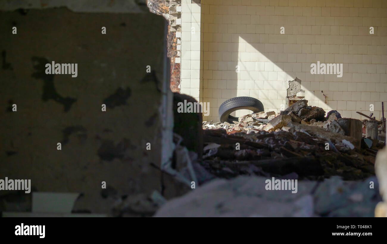 Lots of rubbles on the ground with a tire inside the ruined house from ...