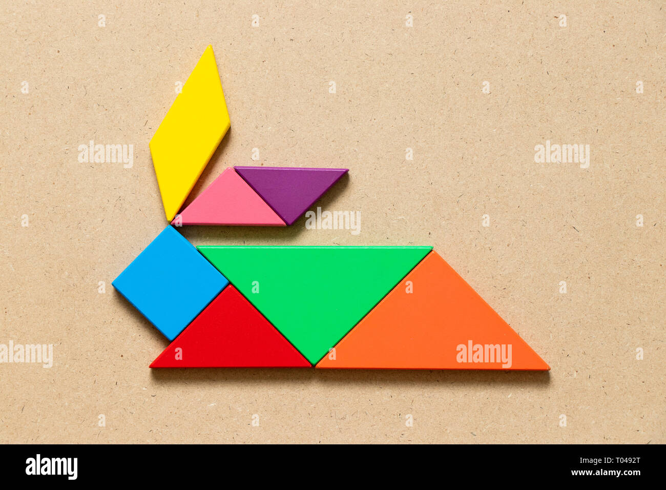Color tangram puzzle in rabbit shape on wood background Stock Photo - Alamy